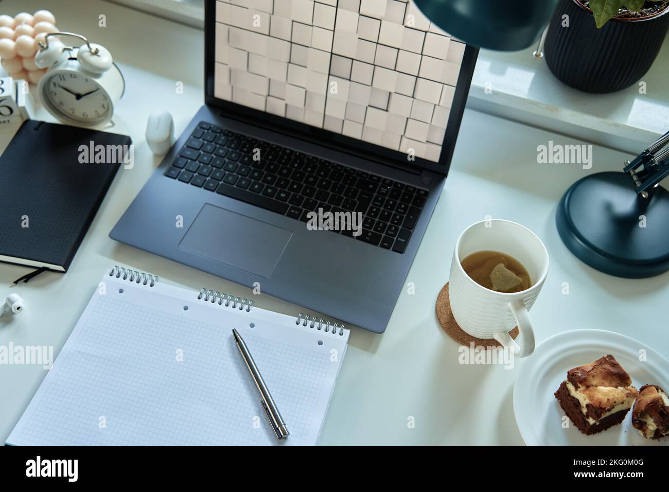 Home office workplace with laptop, documents and cup of tea placed on ...