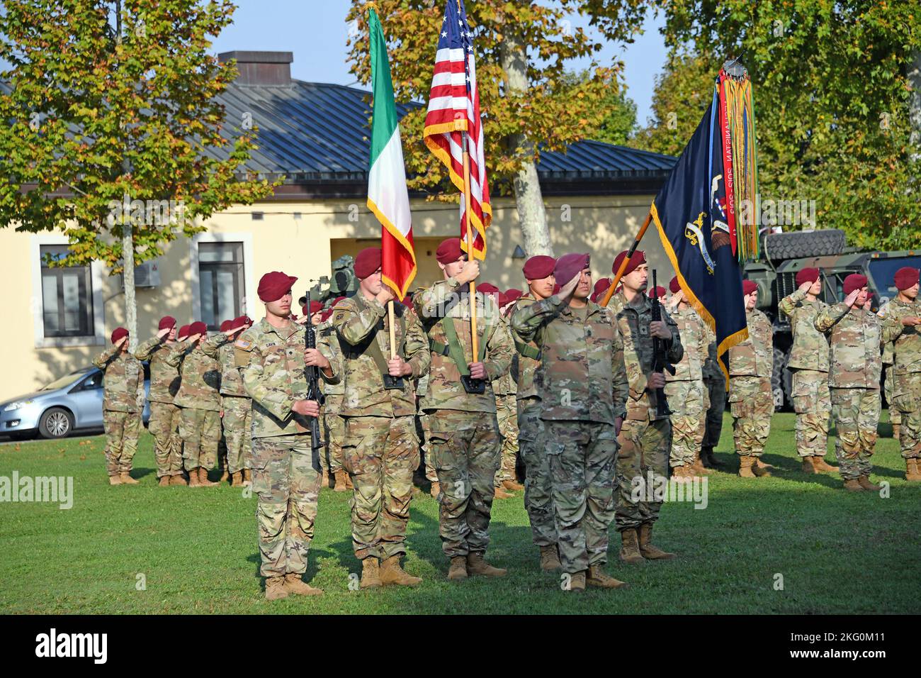 Soldiers from U.S. and Italian units render a salute while the Italian ...