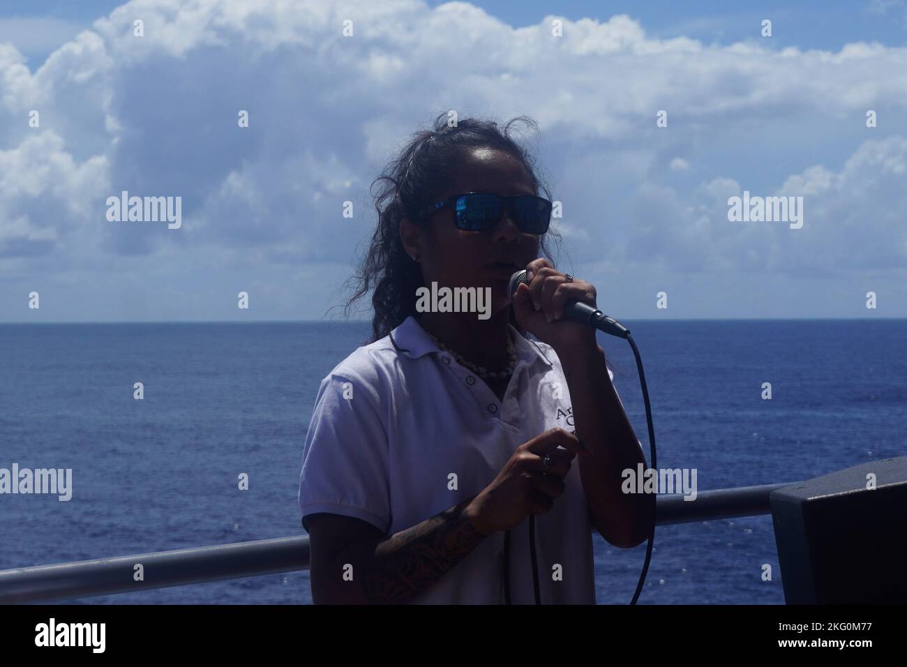 Close Up of a Backlit Cruise Ship Entertainment Team Member speaking ...
