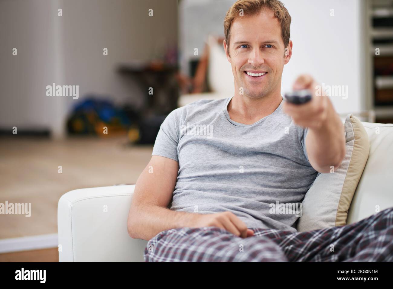 Smiling man holding remote hi-res stock photography and images - Alamy