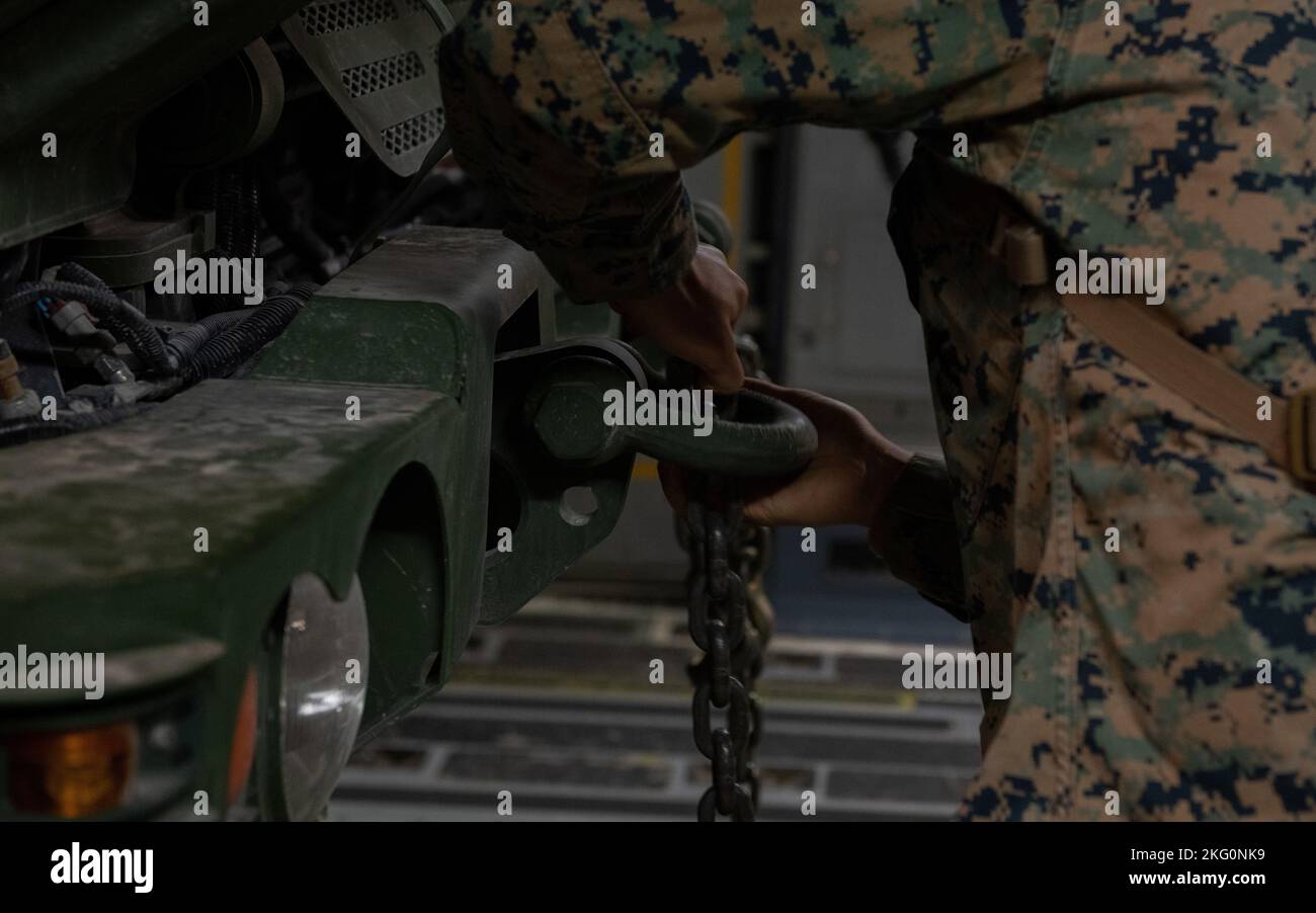 A U.S. Marine attaches a chain to a High Mobility Air Rocket System ...