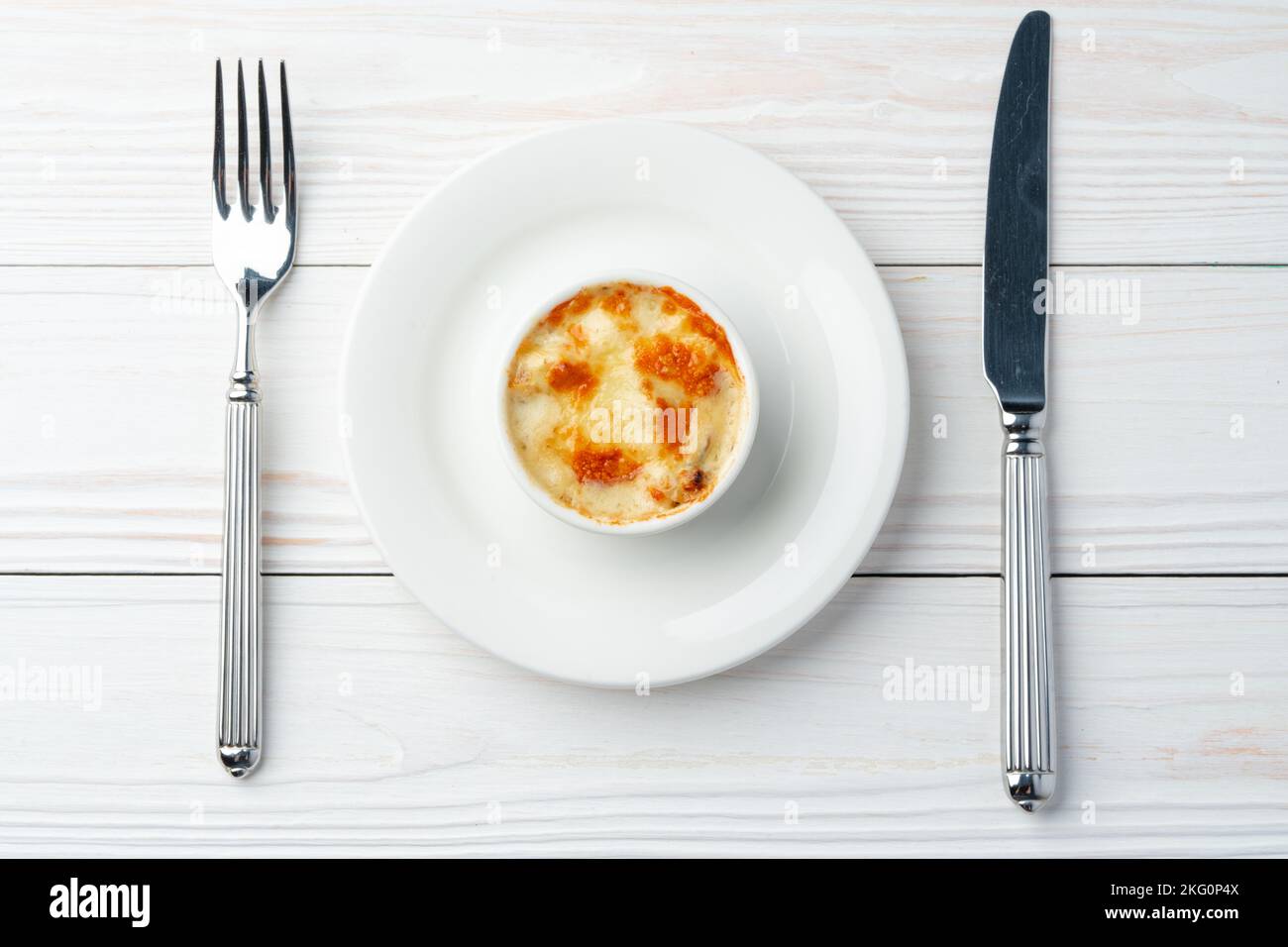 Baked julienne with mushrooms and cheese on top on white plate Stock ...