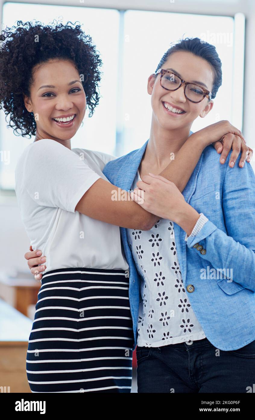 Workplace friends. Portrait of two female coworkers embracing happily ...