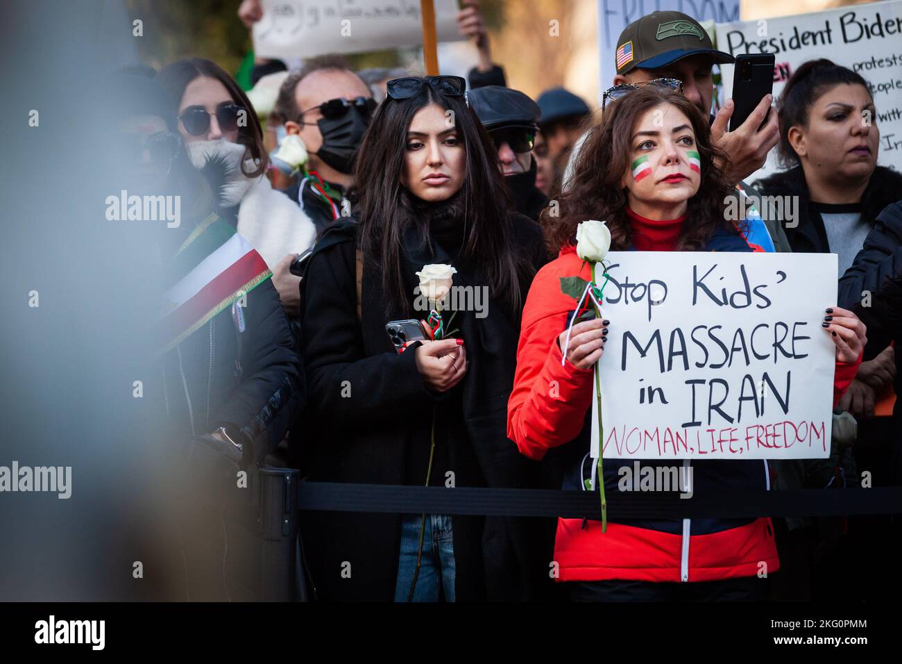 People at a rally hold white roses in memory of the children killed ...