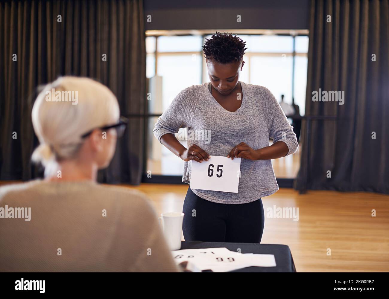Shes next up. a female dancer attaching her competition number to her ...