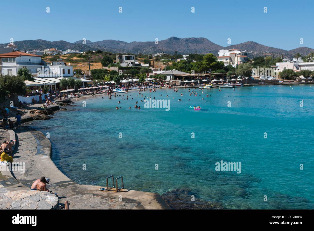 A coastline view of people having fun at the beach under the blue ...