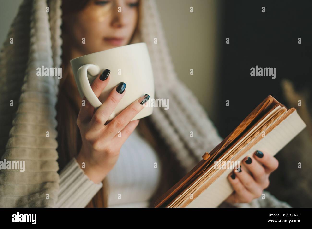 Relaxed woman at home living room sitting on the couch, reading a book ...