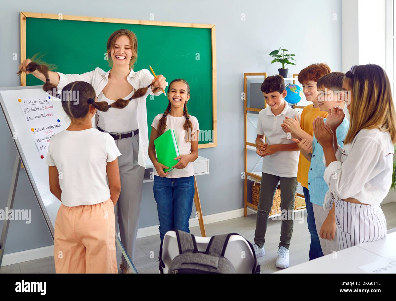 Female teacher and playful schoolchildren having fun and fooling around ...