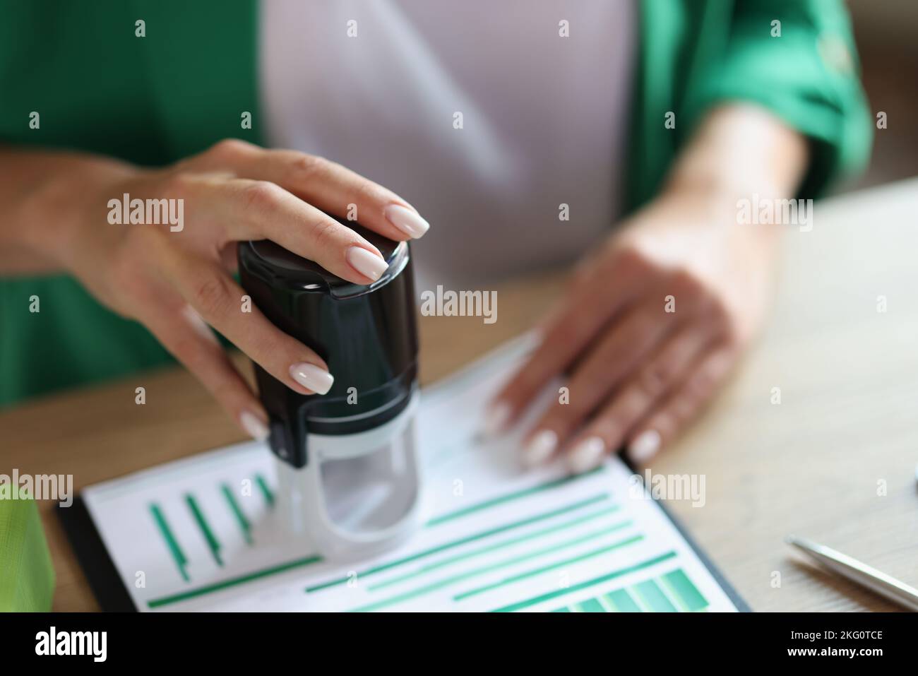 Woman hand holding rubber-stamp and stamping statistics documents Stock ...