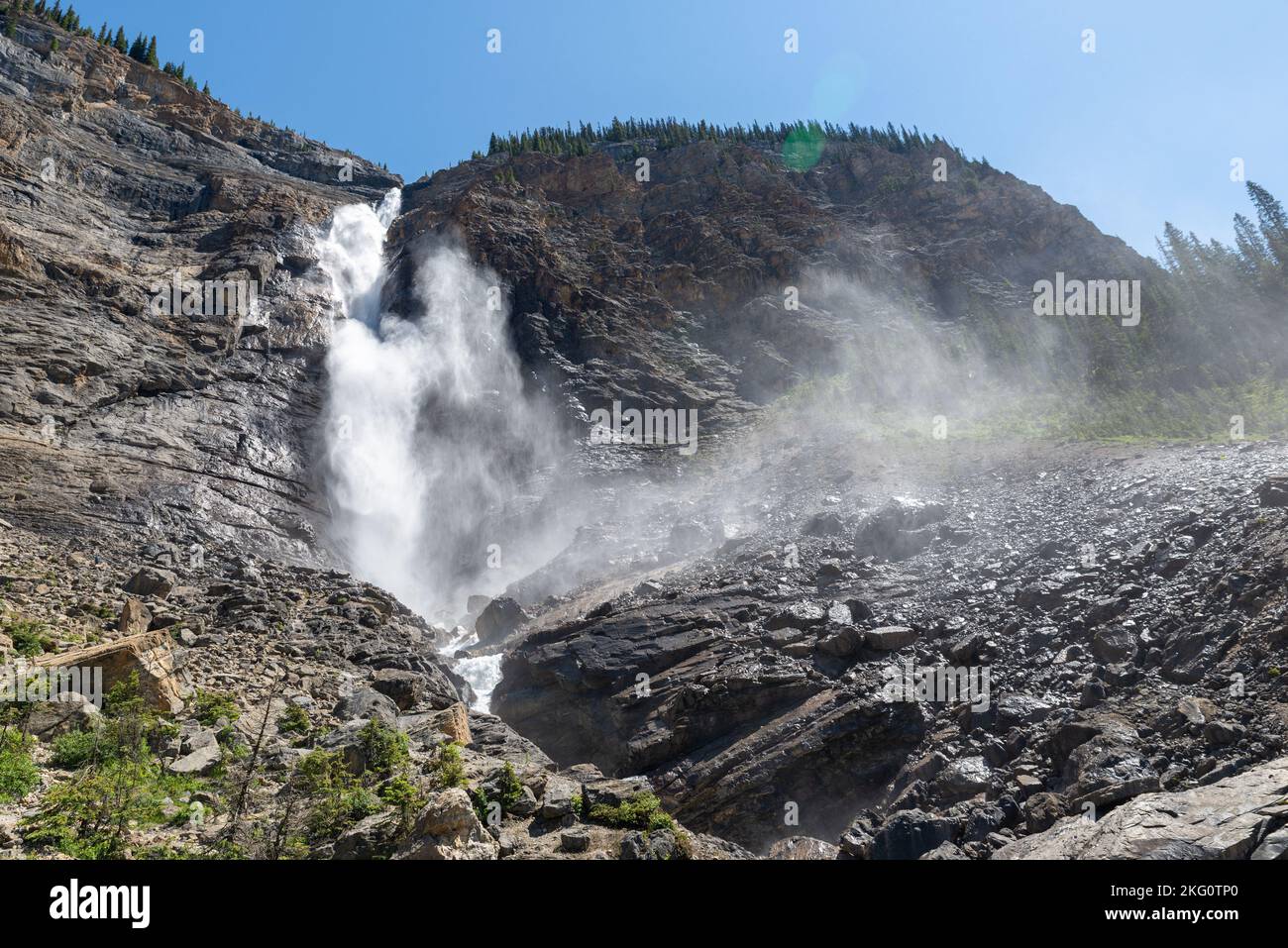 A scenic view of a waterfall flowing down the rocks in Yoho national ...