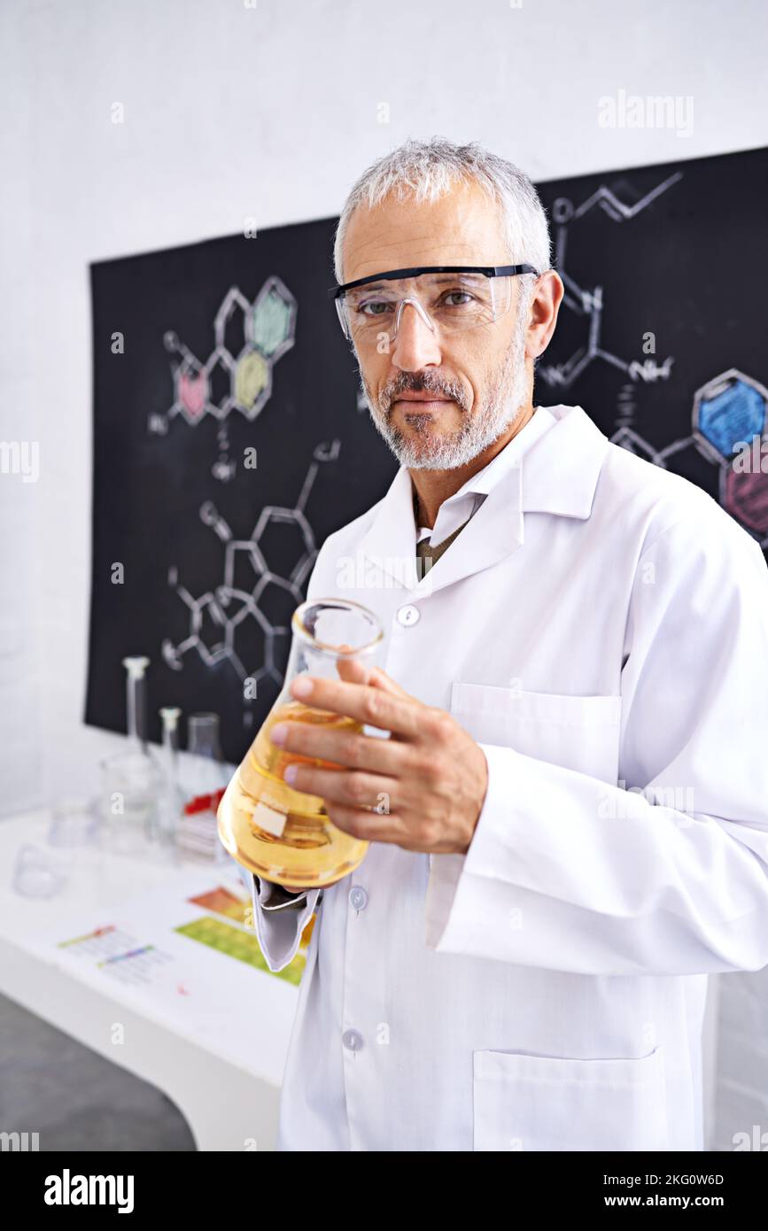 Unraveling chemistry. Portrait of a mature male scientist doing a ...