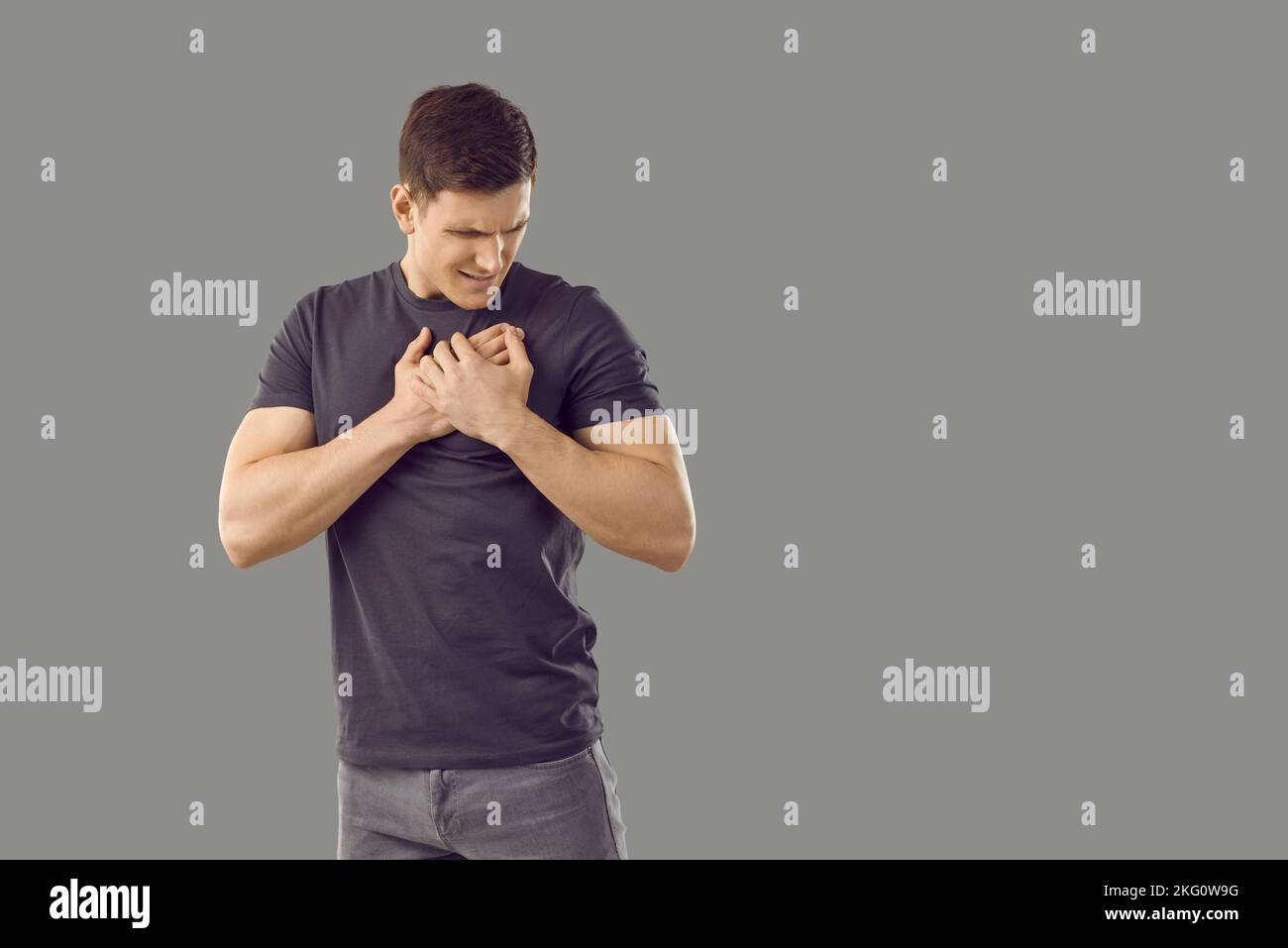 Man standing on copy space background feeling pain in his heart and ...