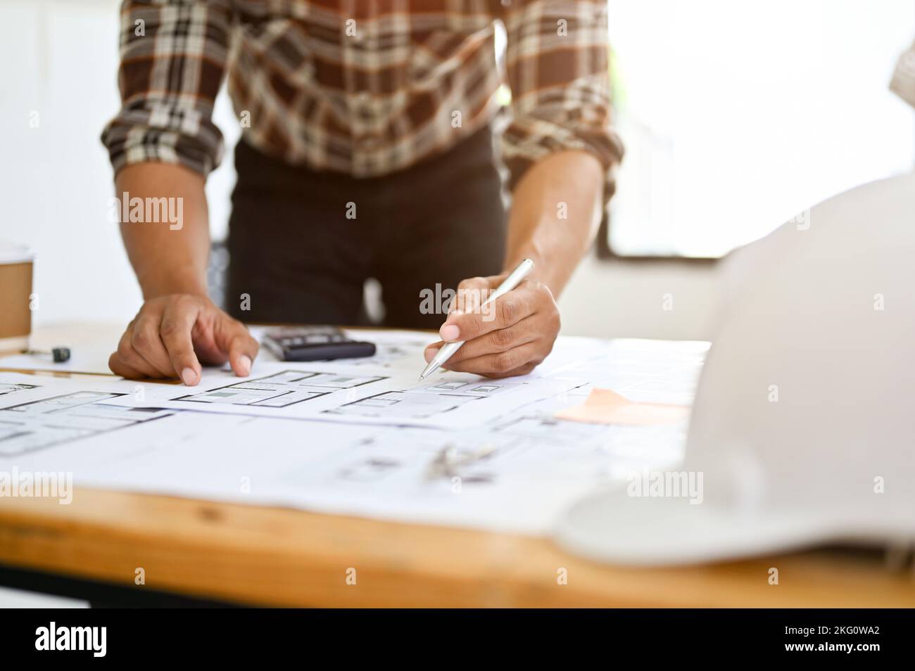 Professional Asian male engineer or architect checking building scale ...