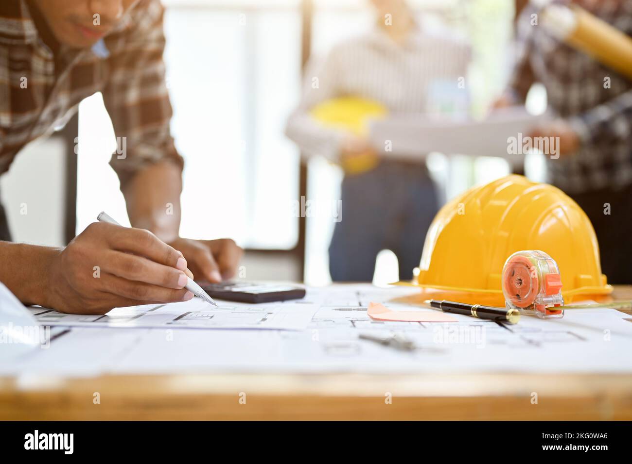 Professional Asian male engineer or architect checking building scale ...