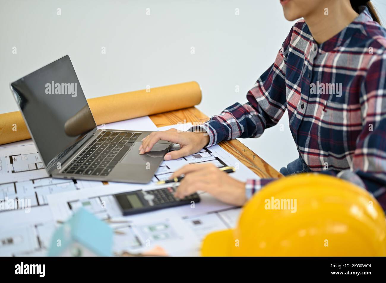 A female architect or engineer working at her desk, using scientific ...
