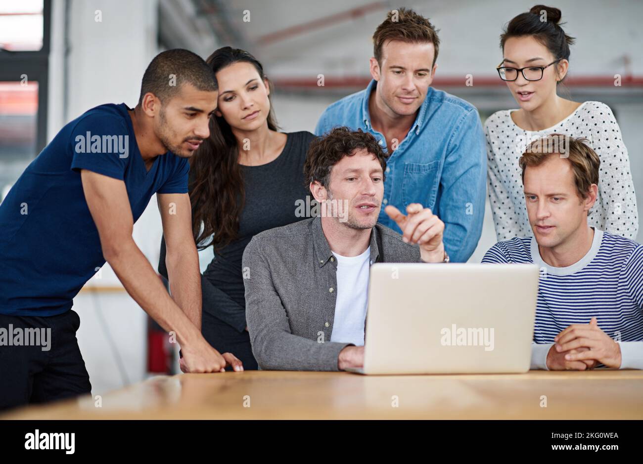 Design in progress. a group of colleagues using a laptop together in a ...