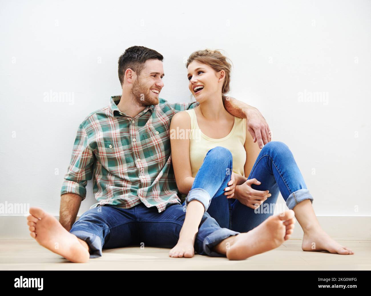 Carefree romantic moments. an affectionate young couple sitting beside ...