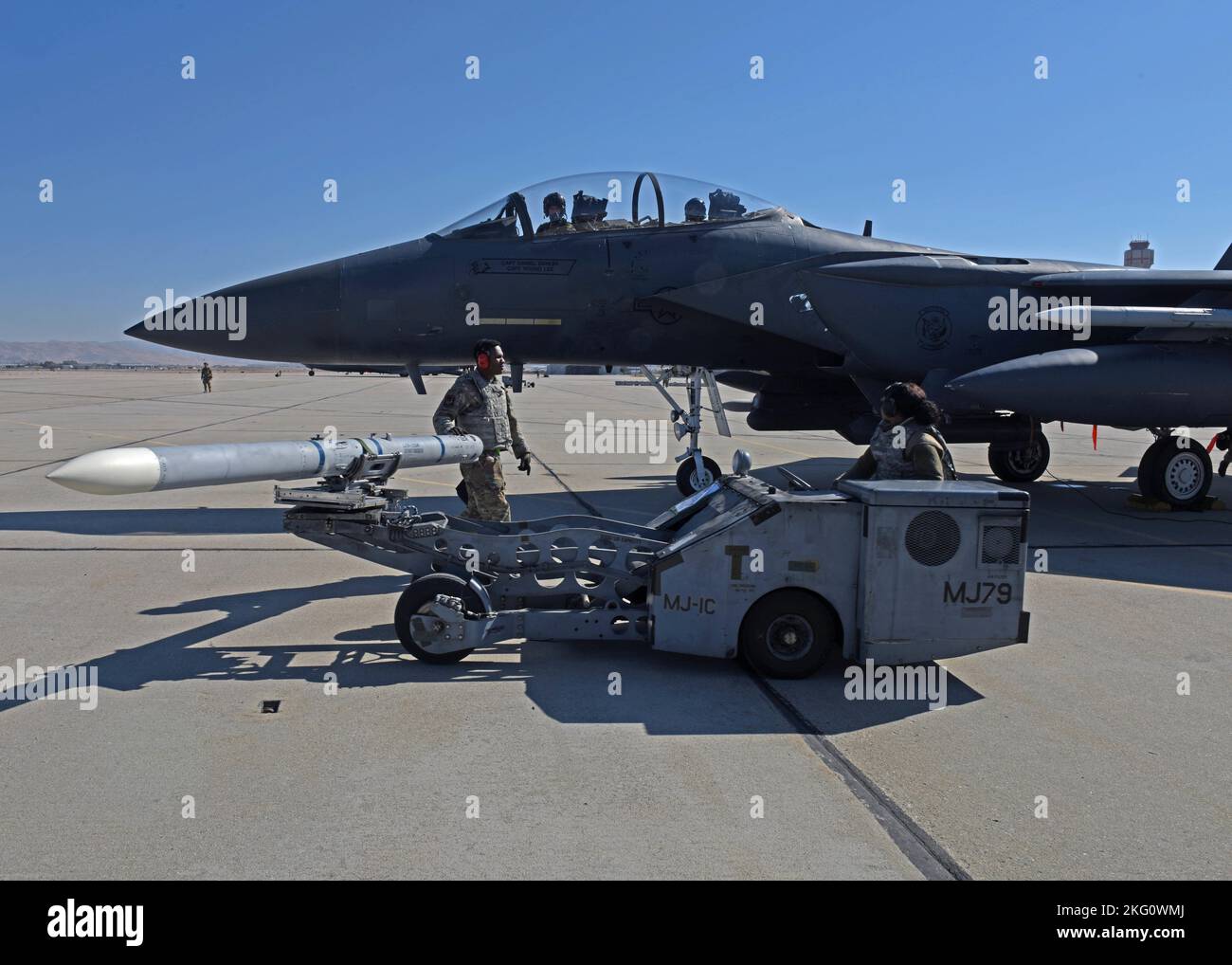 U.S. Airmen with the 366th Munitions Squadron load munitions onto an F-15E Strike Eagle aircraft ...