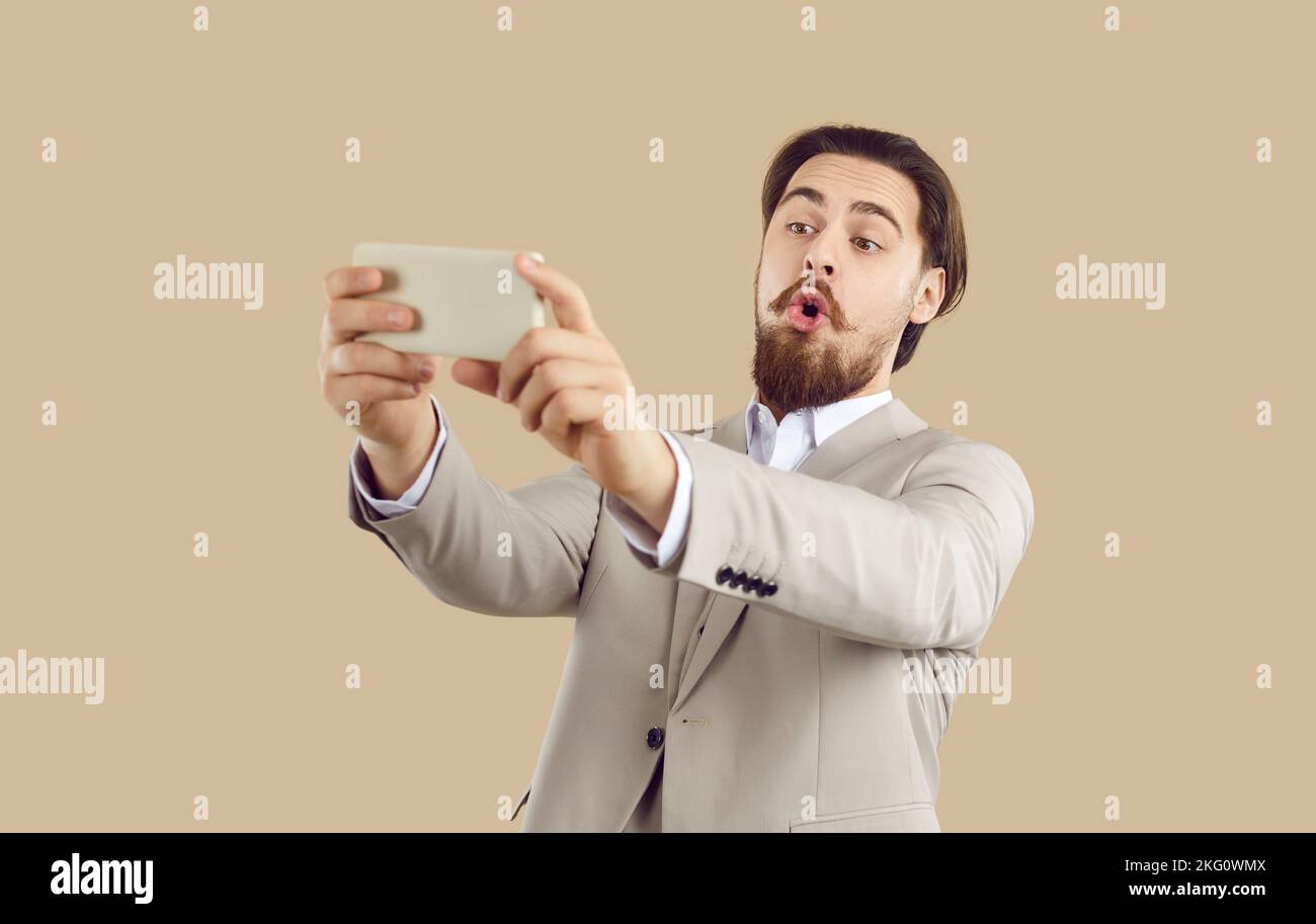 Funny businessman taking selfie pleasantly surprised by quality of ...