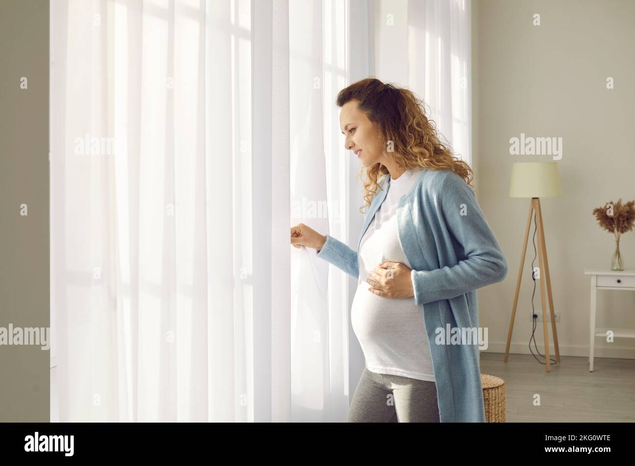 Young pregnant woman stay at home look in window Stock Photo - Alamy
