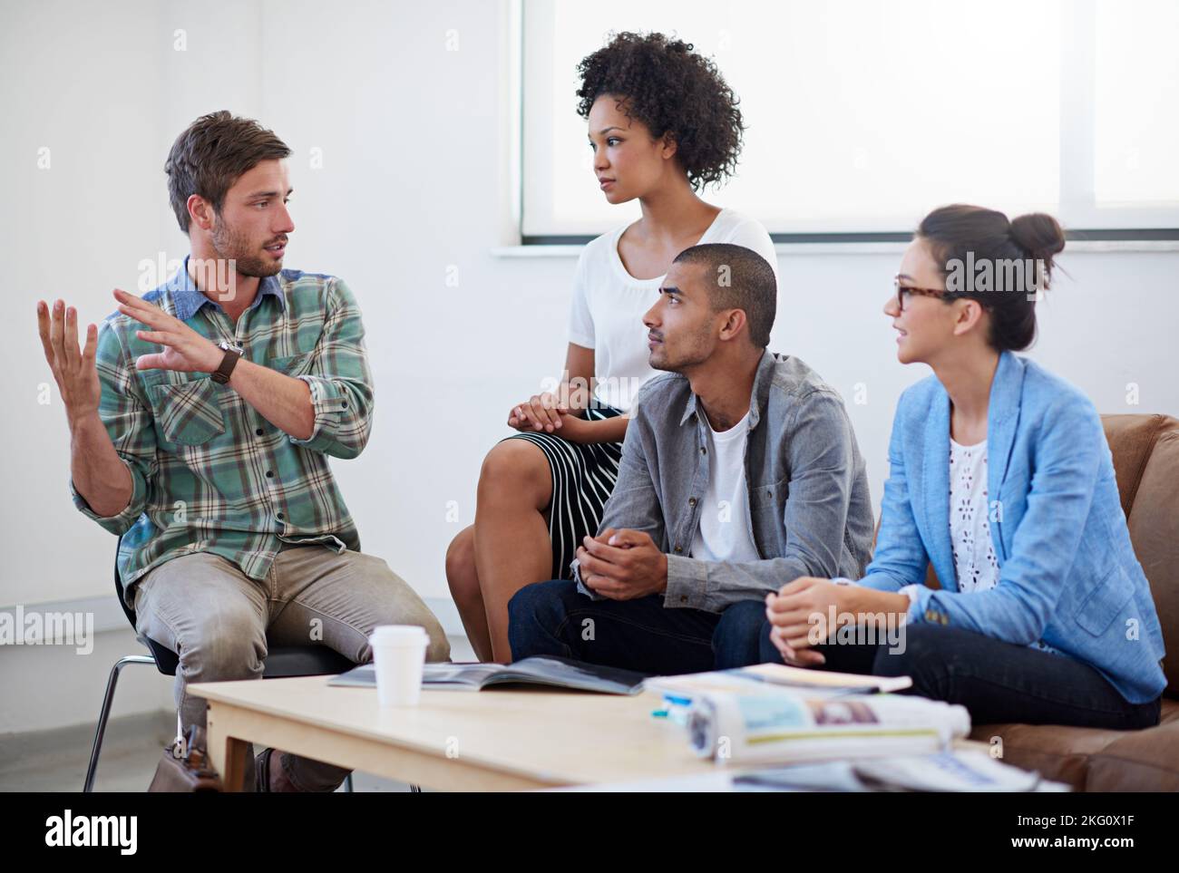 Talking points. a diverse group of designers having a meeting around a ...