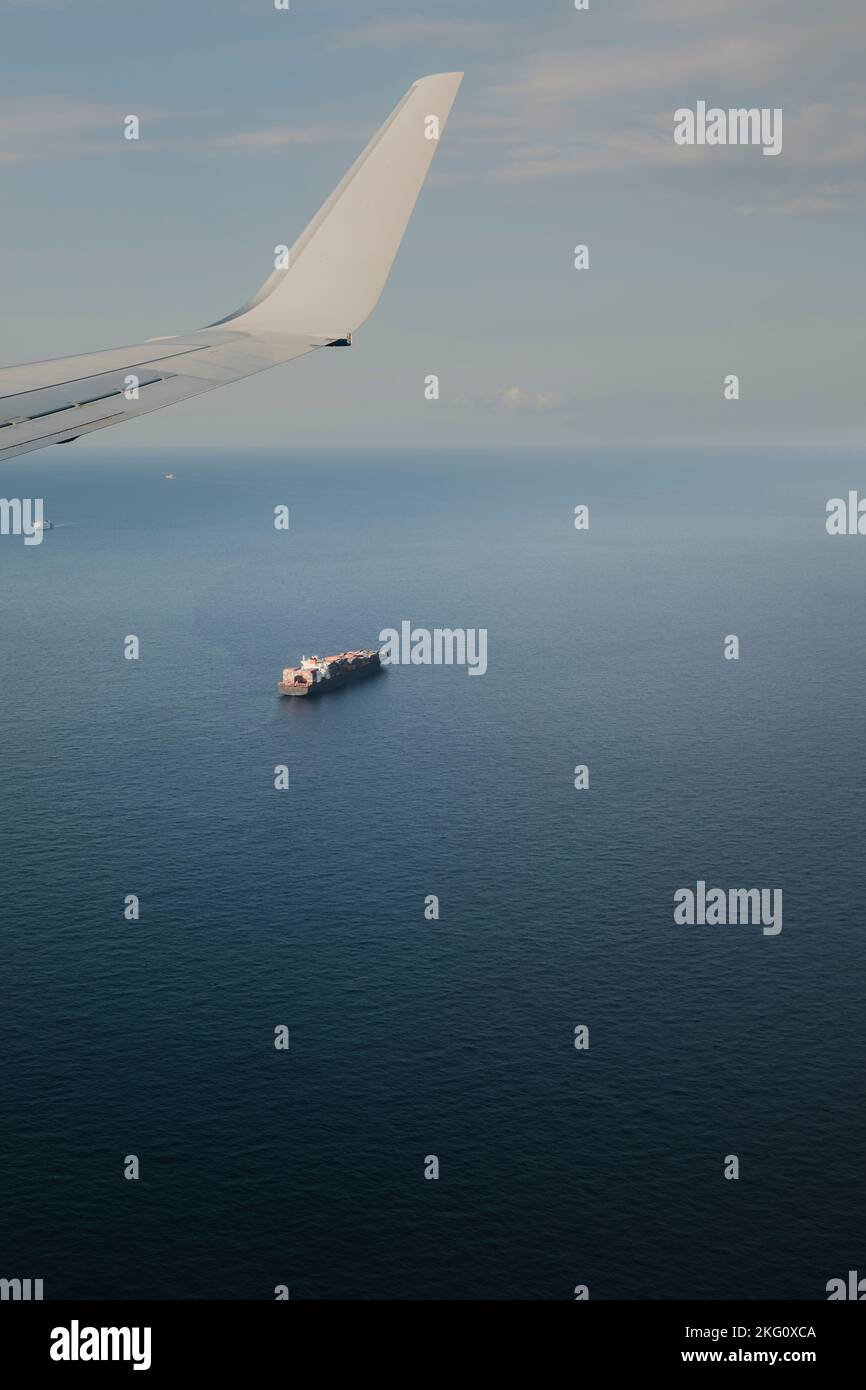 Cargo freight ship on a plain sea landscape seen from an airplane ...