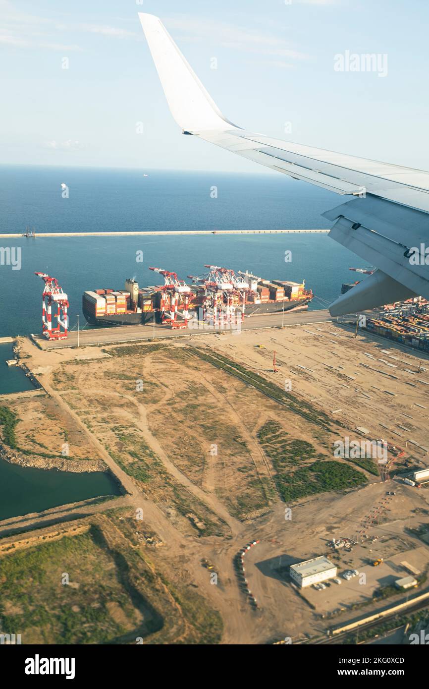 Many cargo containers and fright boats on a harbour seen from an ...