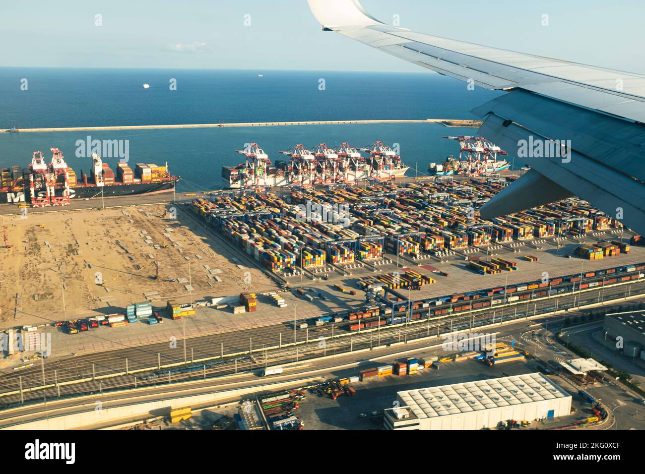 Many cargo containers and fright boats on a harbour seen from an ...