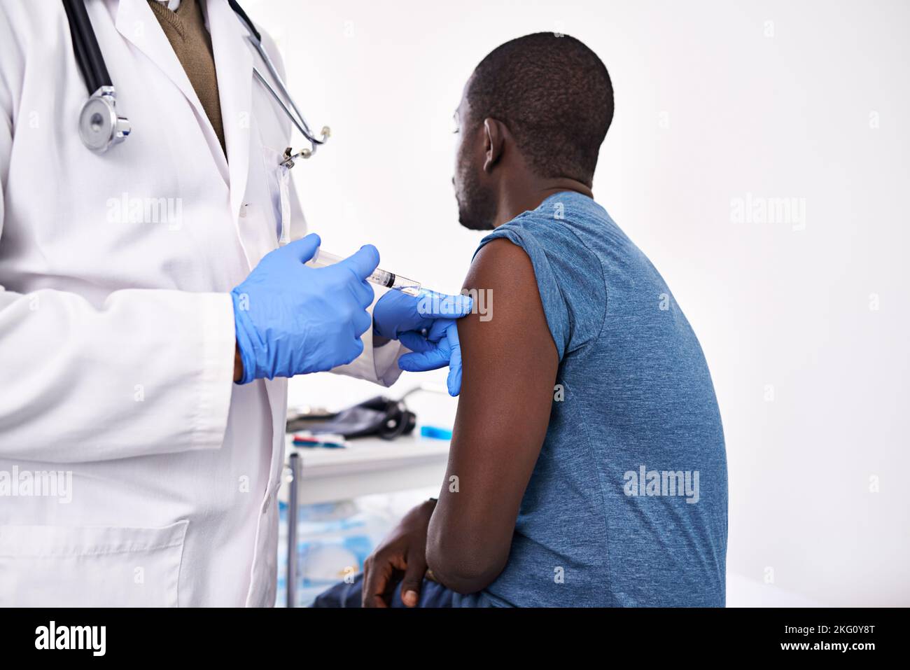 Hes in for his annual flu shot. a male doctor giving his patient an ...