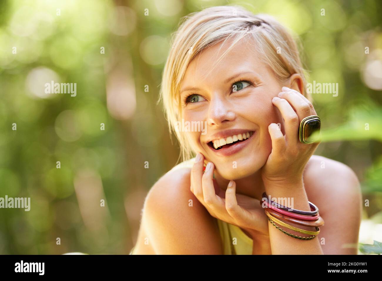 Having a laugh in nature. An attractive young woman laughing outside in ...