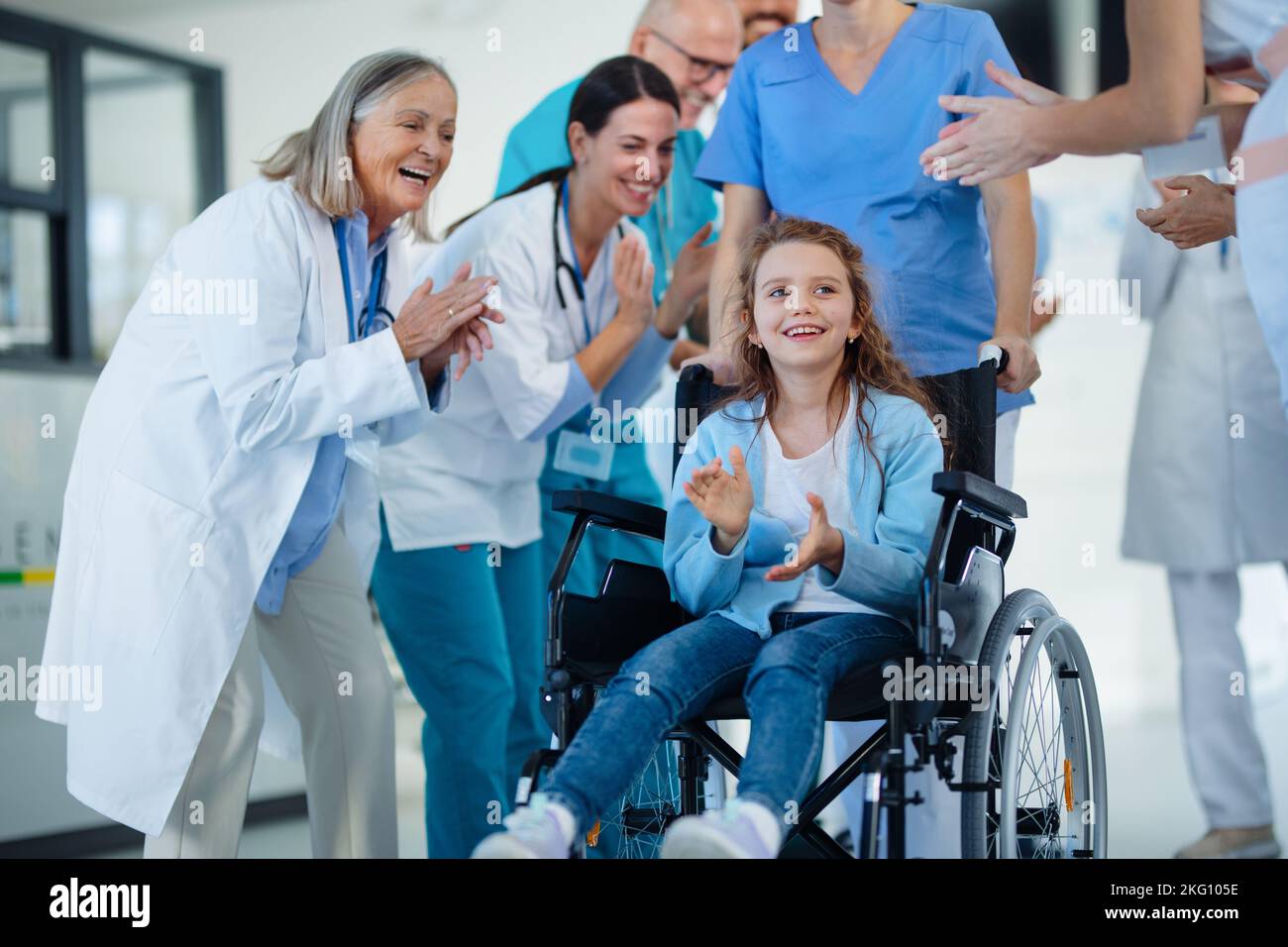 Medical staff clapping to little girl patient who recovered from ...