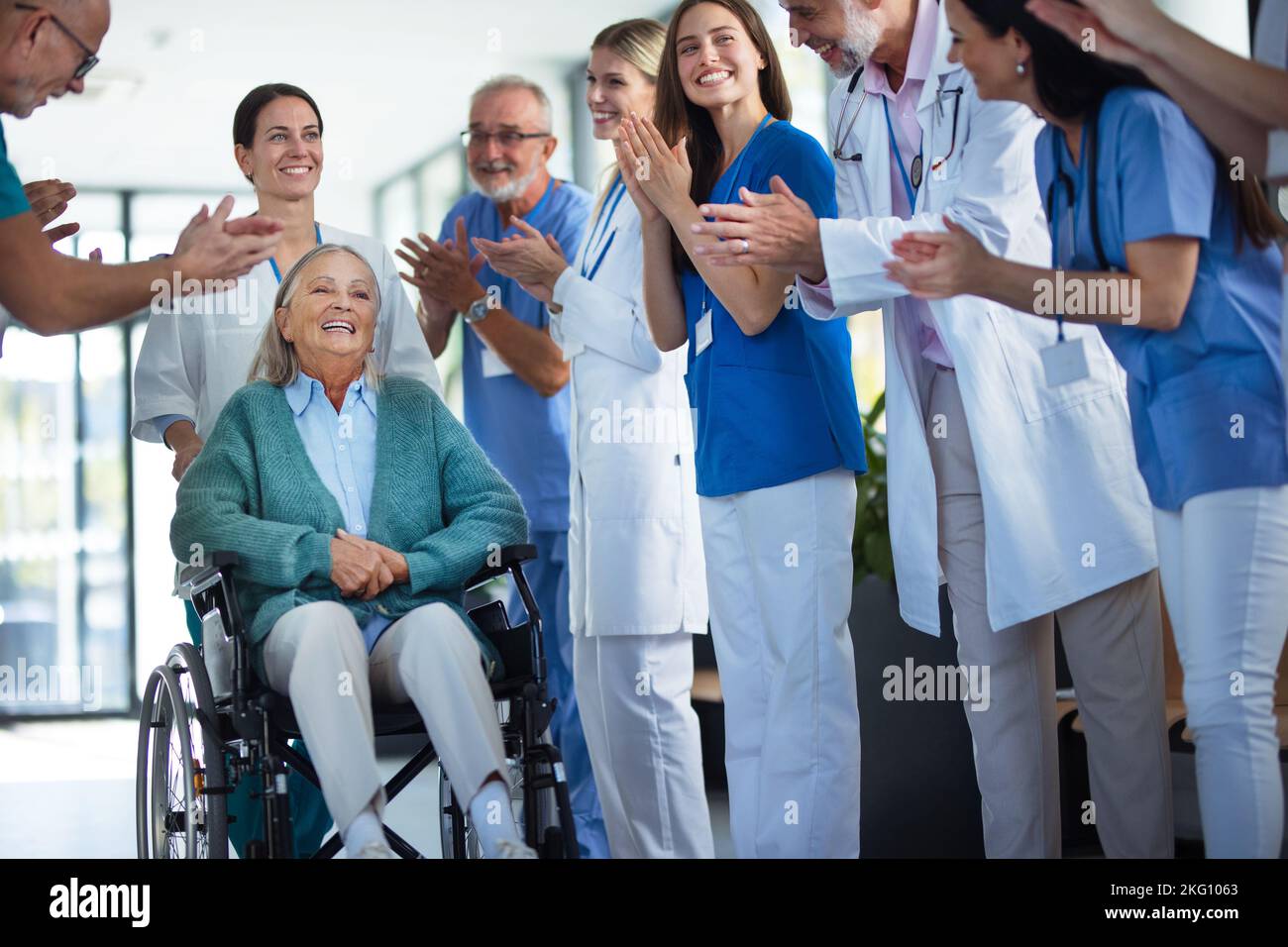 Medical staff clapping to patient who recovered from serious illness ...