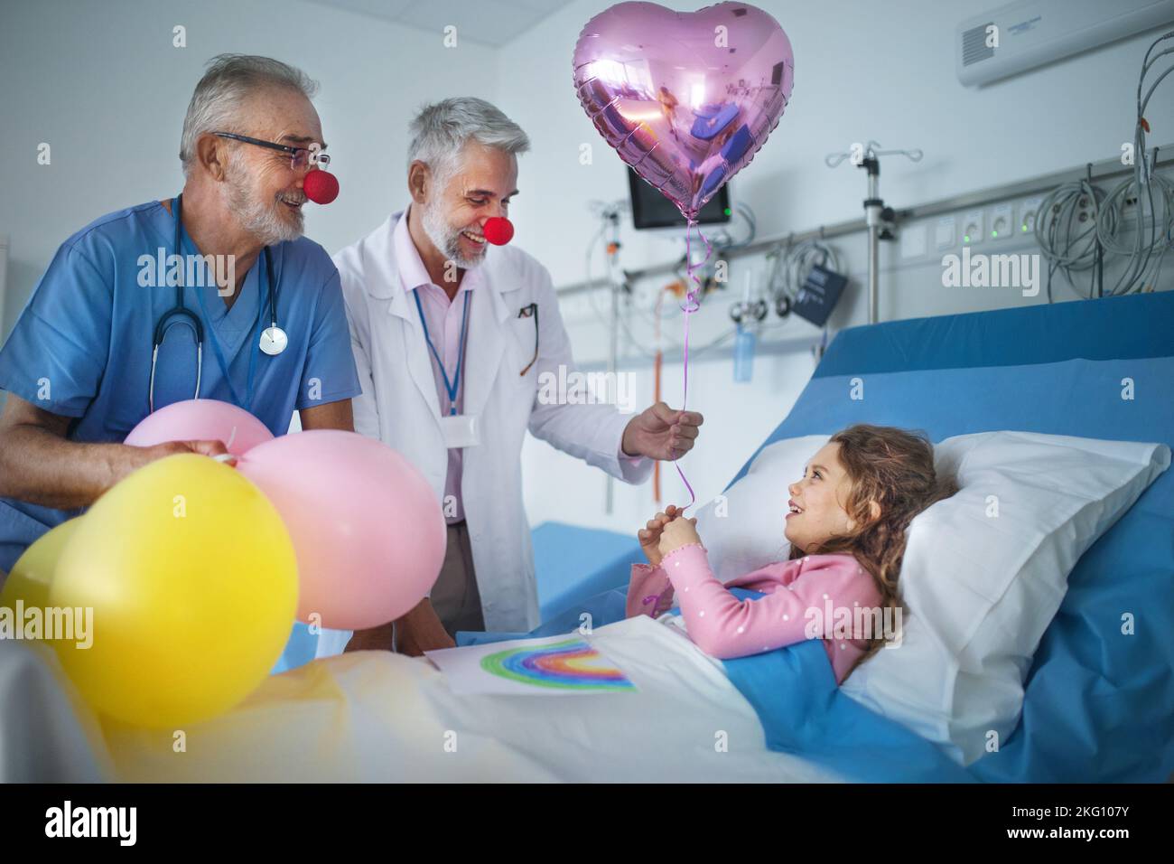 Happy doctors with clown red noses celebrating birthday with little ...