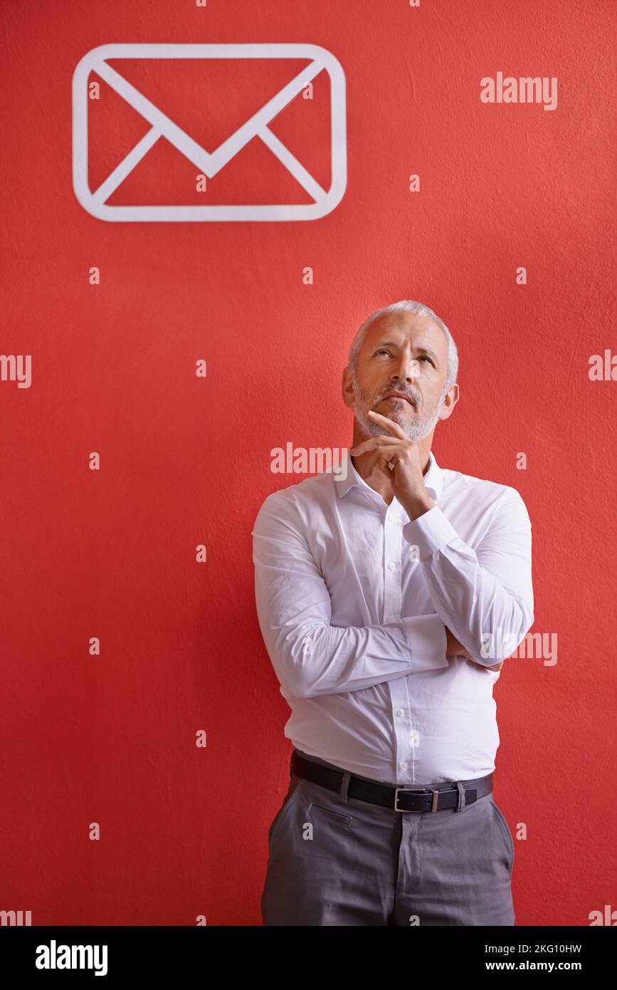 Composing a professional email. A mature businessman looking thoughtful ...