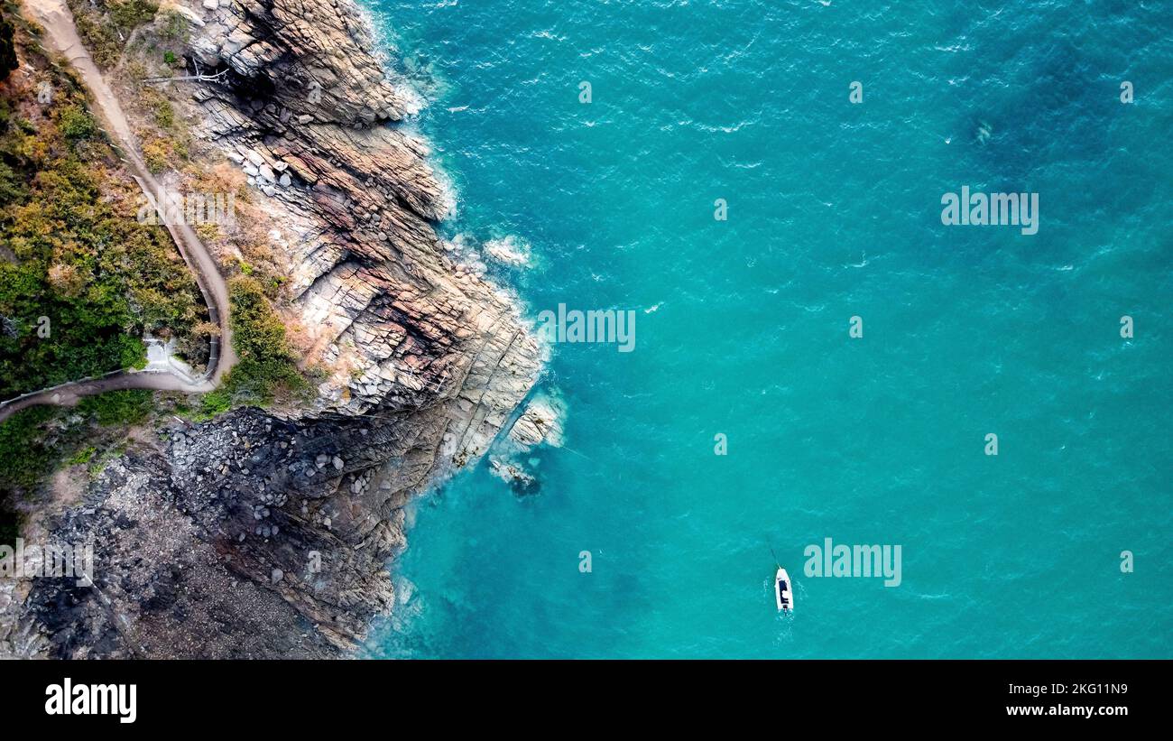An aerial shot of the rocky edge of an island in the ocean with a ...