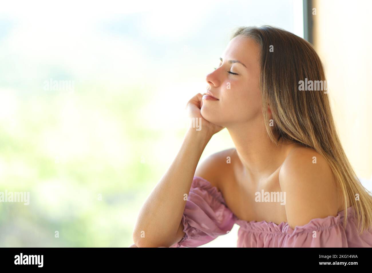 Teen beside a window relaxing with closed eyes at home or hotel Stock ...