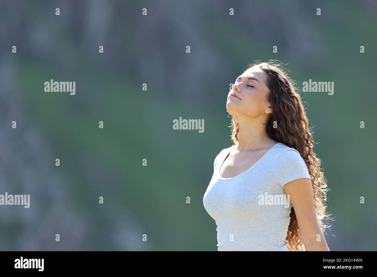 Casual relaxed woman breathing fresh air standing in nature Stock Photo ...