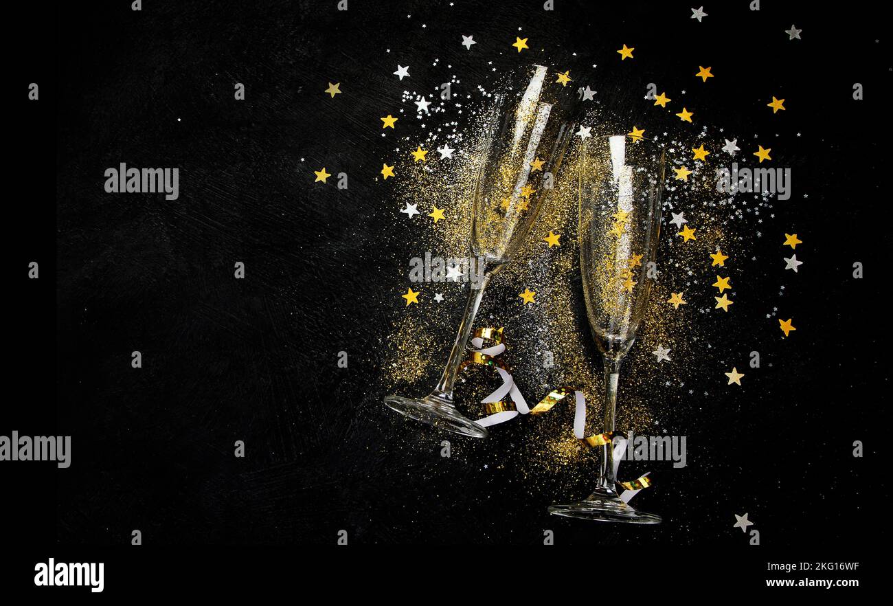 Two champagne glasses. Christmas decoration on a black background ...