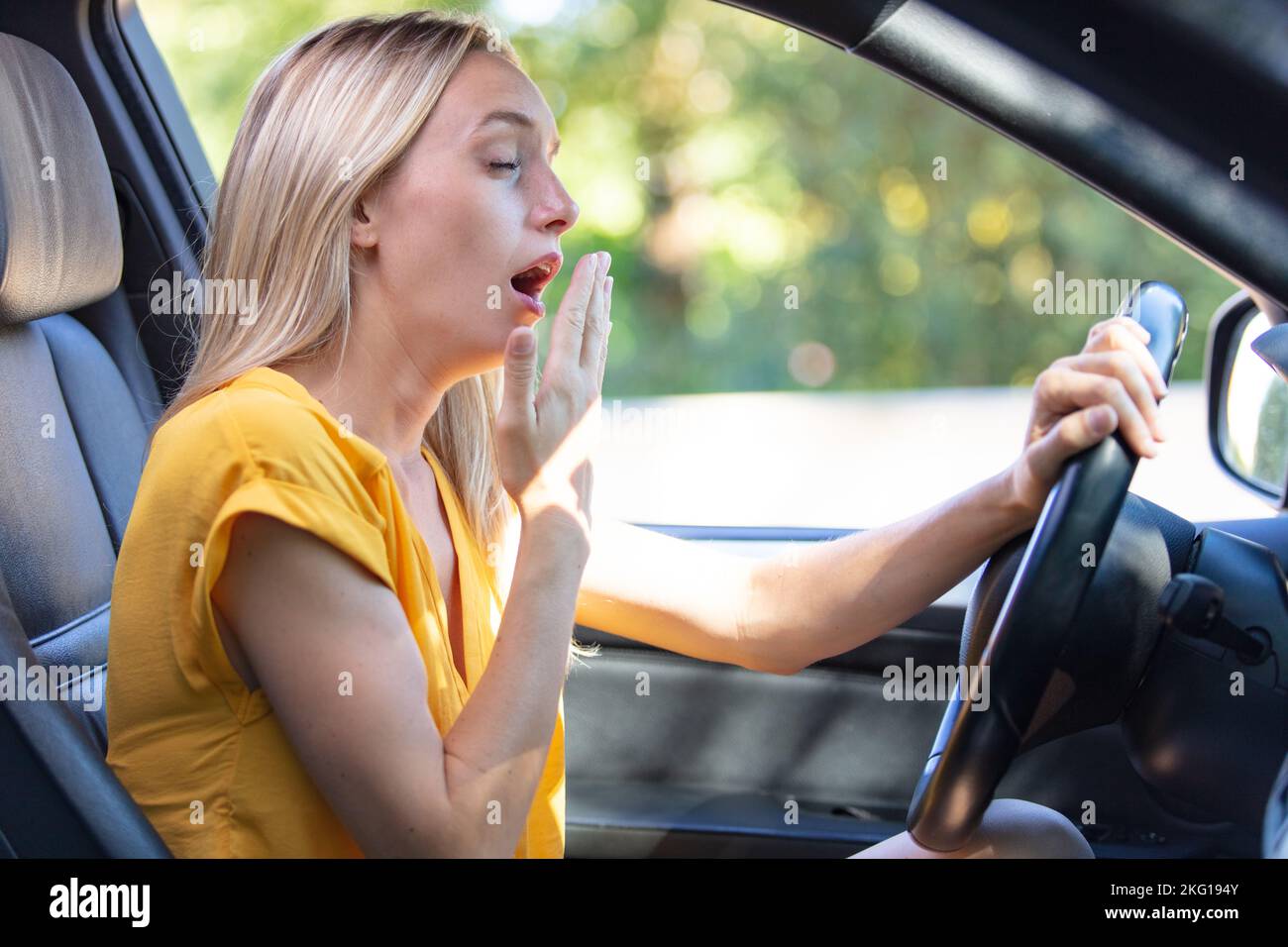 driver girl yawns while driving a car Stock Photo - Alamy