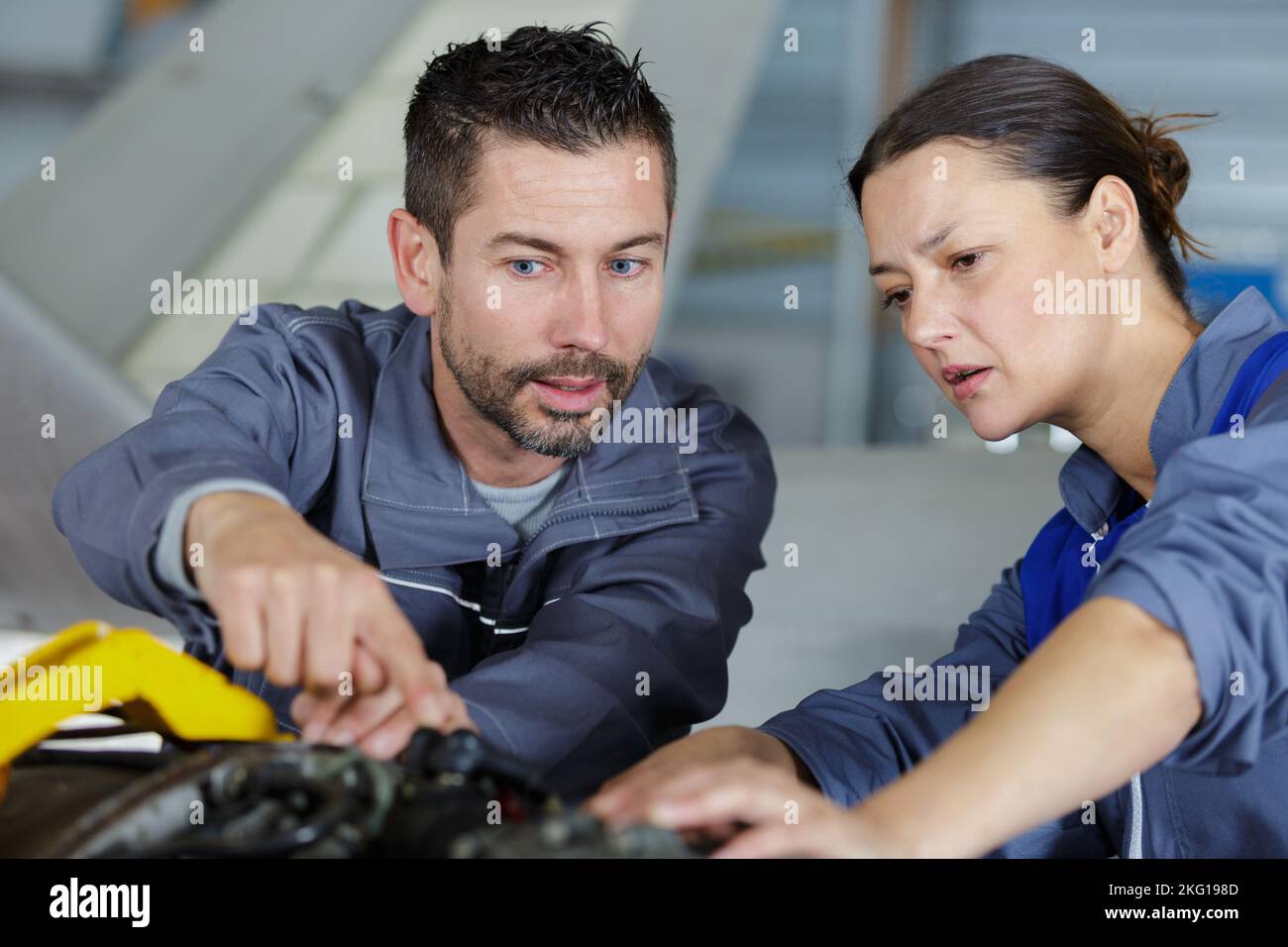 mechanic giving instructions to female colleague Stock Photo - Alamy