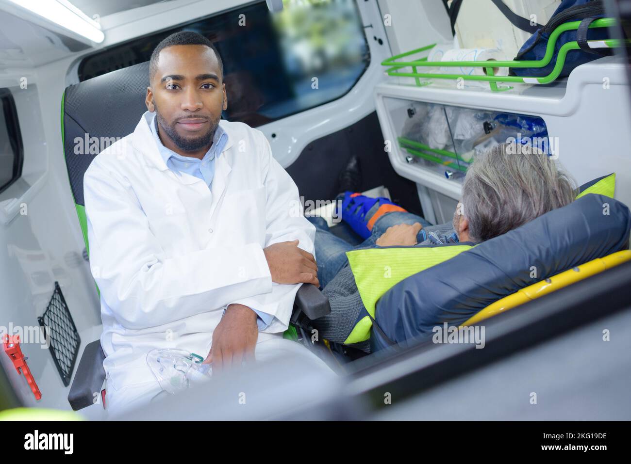 male doctor taking pulse of a man inside ambulance Stock Photo - Alamy