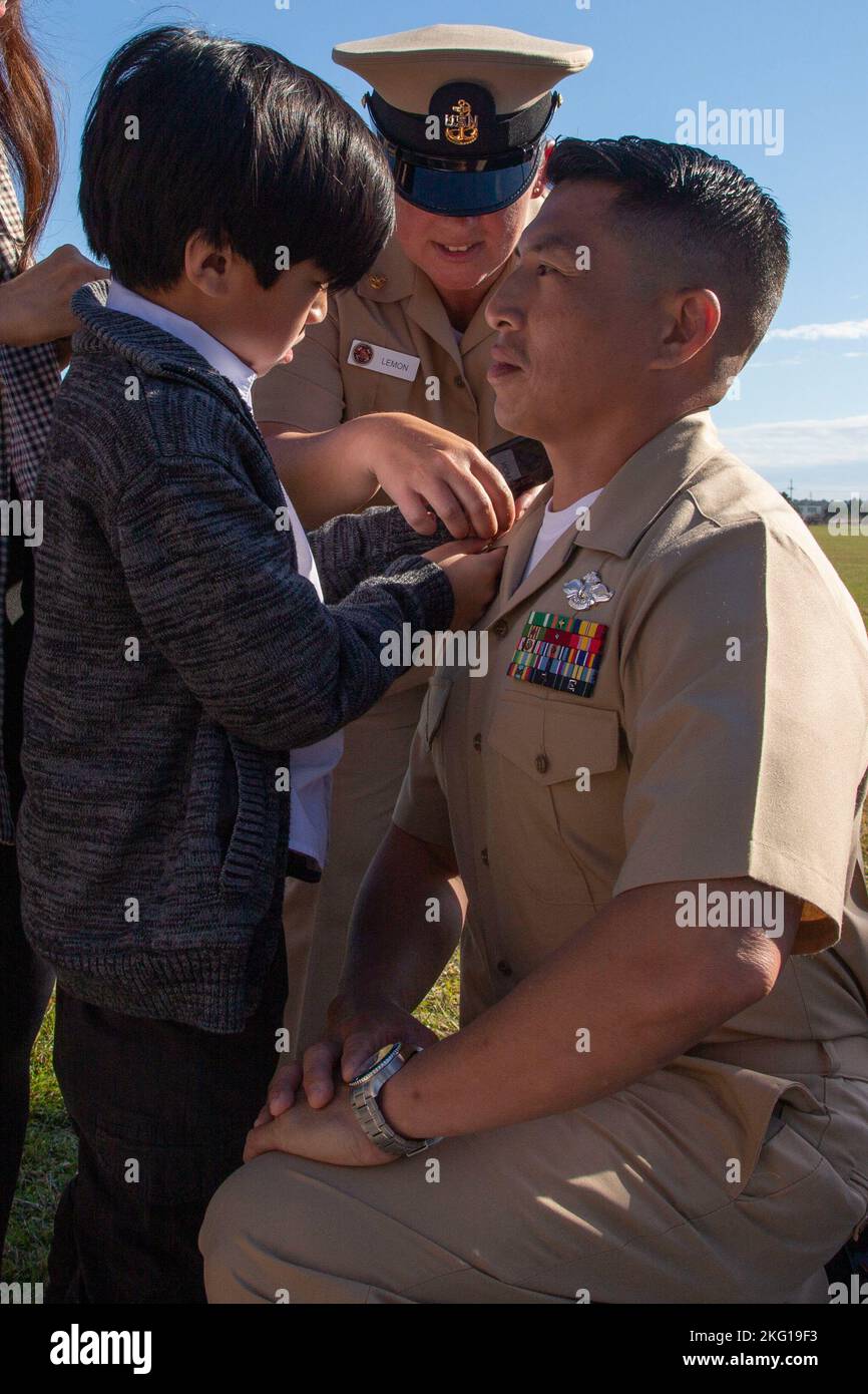 A newly promoted chief petty officer is pinned to his new rank by his ...