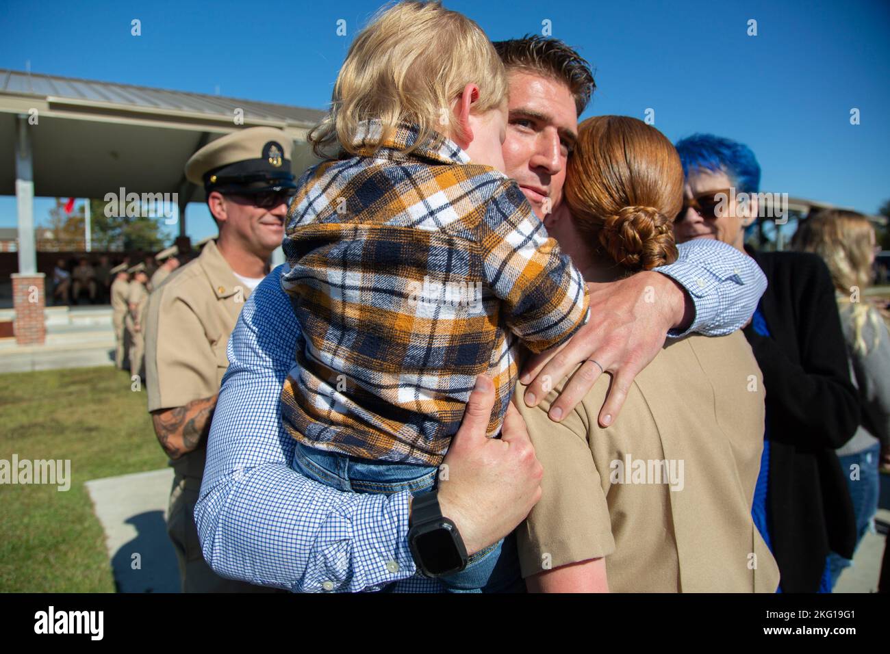 A newly promoted chief petty officer shares a hug with her husband and ...