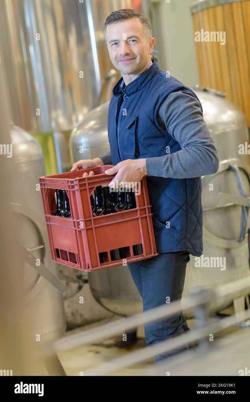 portrait of worker carrying crate of beer in brewery Stock Photo - Alamy