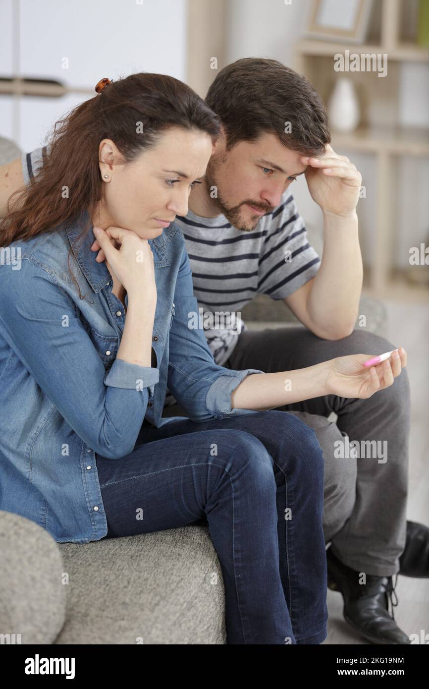 despondent couple are looking at pregnancy test Stock Photo - Alamy