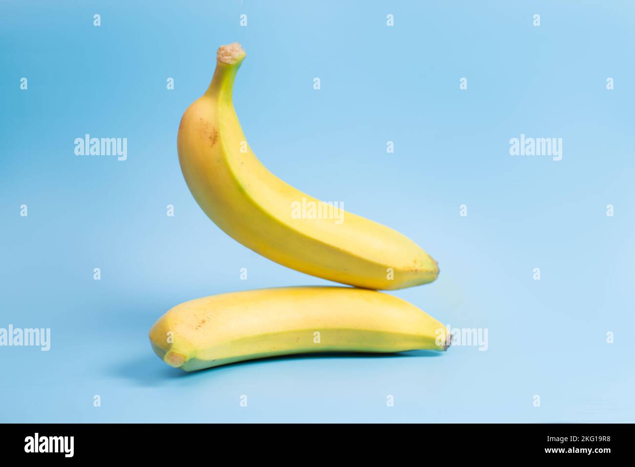 Banana levitation. Two yellow bananas on a blue background Stock Photo ...