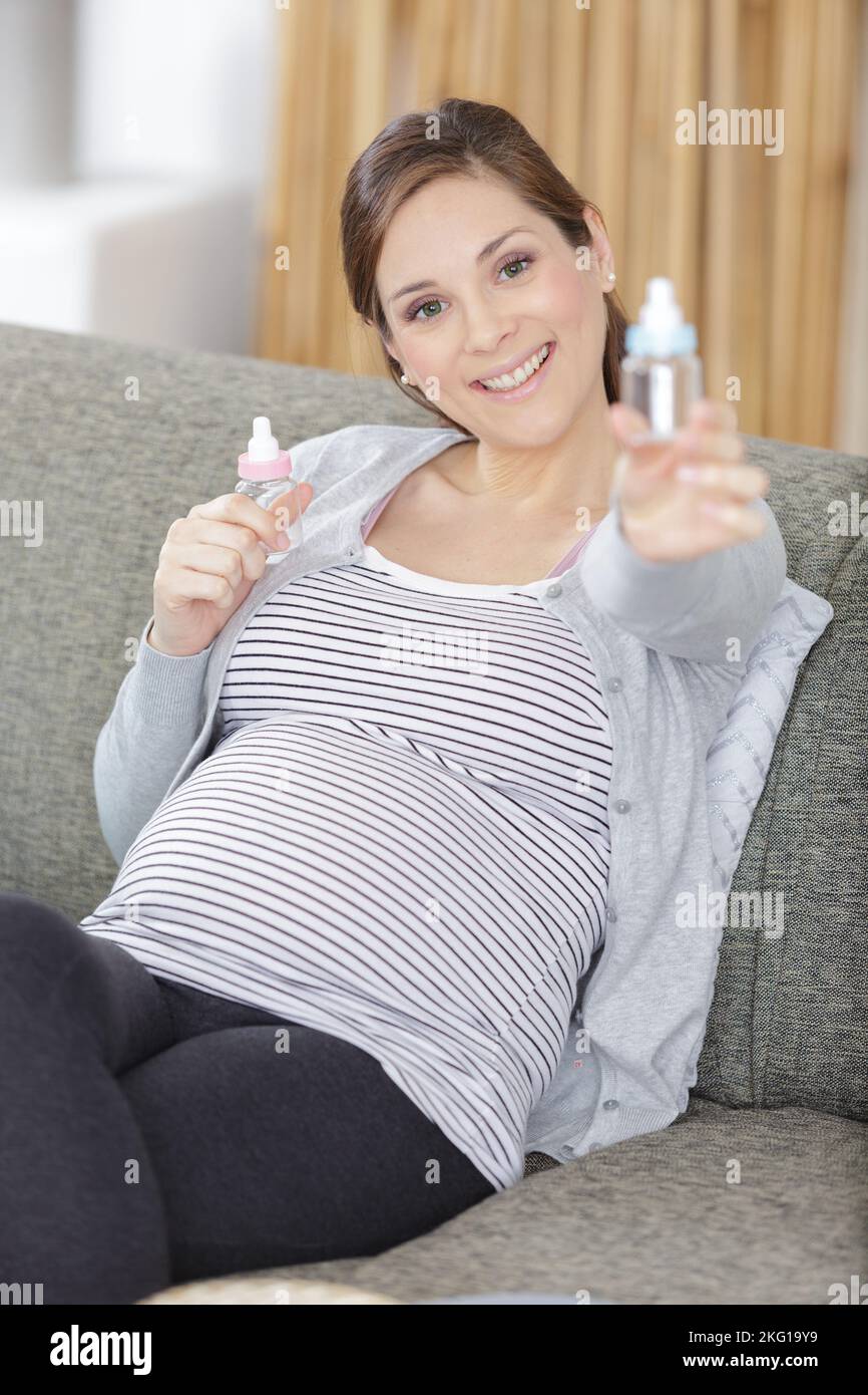 pregnant happy smiling woman sitting on a sofa Stock Photo - Alamy