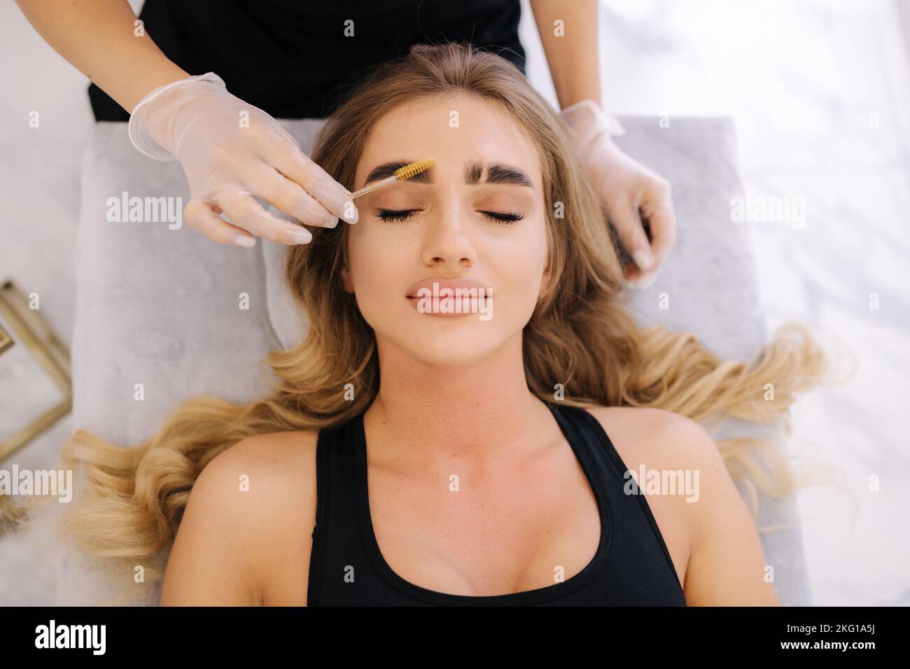 Brow master in transparent glowes gives shape to pull out with forceps ...