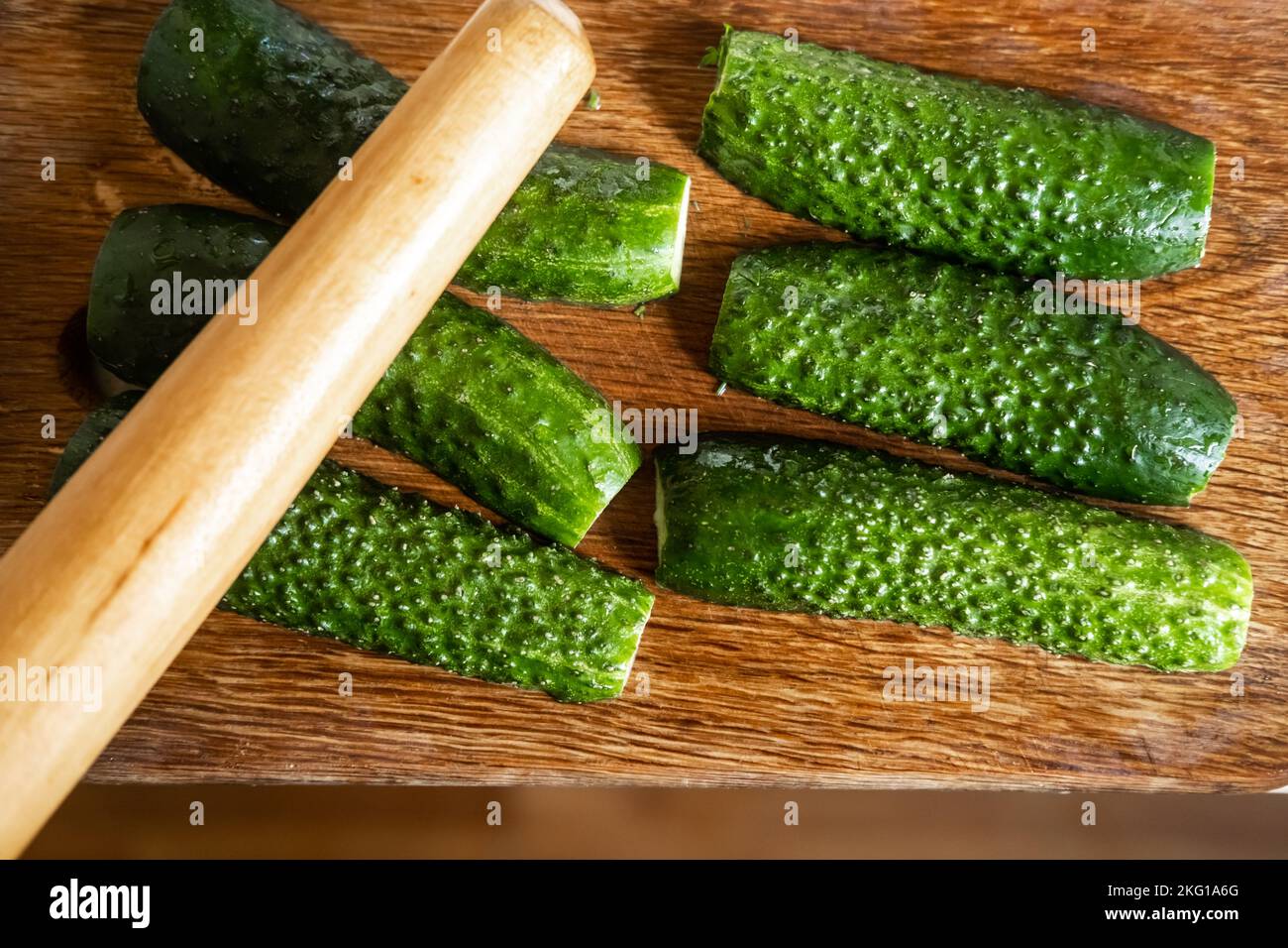 Preparation of beaten cucumbers. Halves of fresh cucumbers on a cutting ...