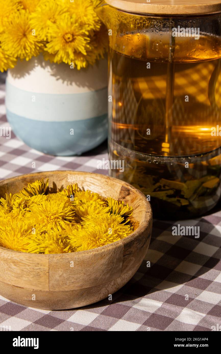 Preparing Dandelion flower healthy tea in glass cup on table. Herbal ...